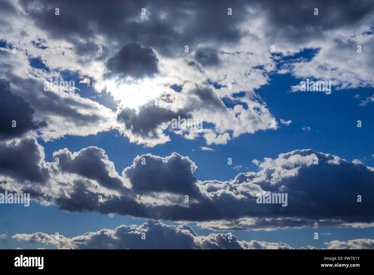 Cumulus clouds on blue sky background highlighted with sun Stock Photo ...