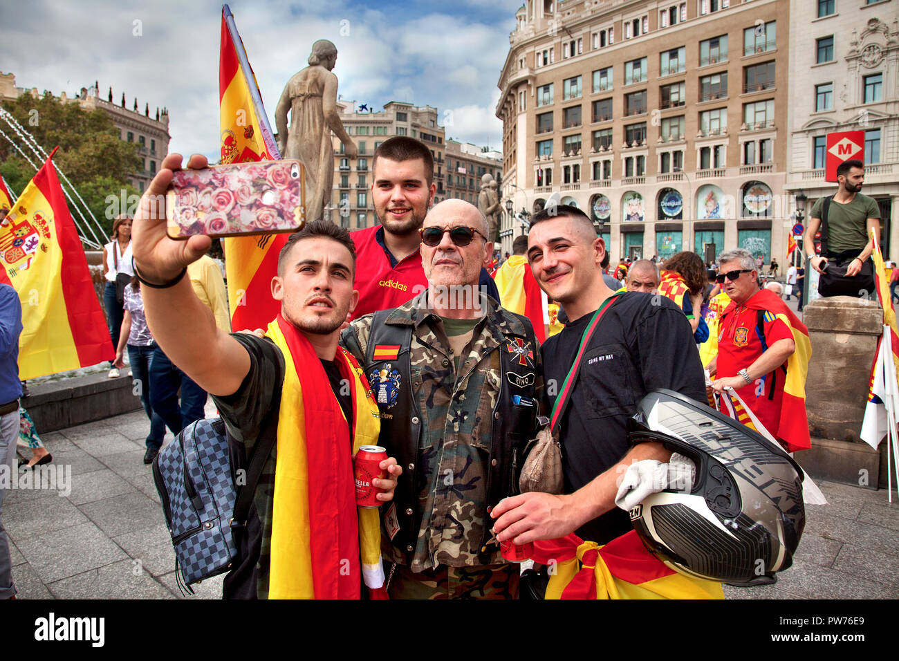 Three young Spanish men pose for a selfie with a soldier from Spanish ...