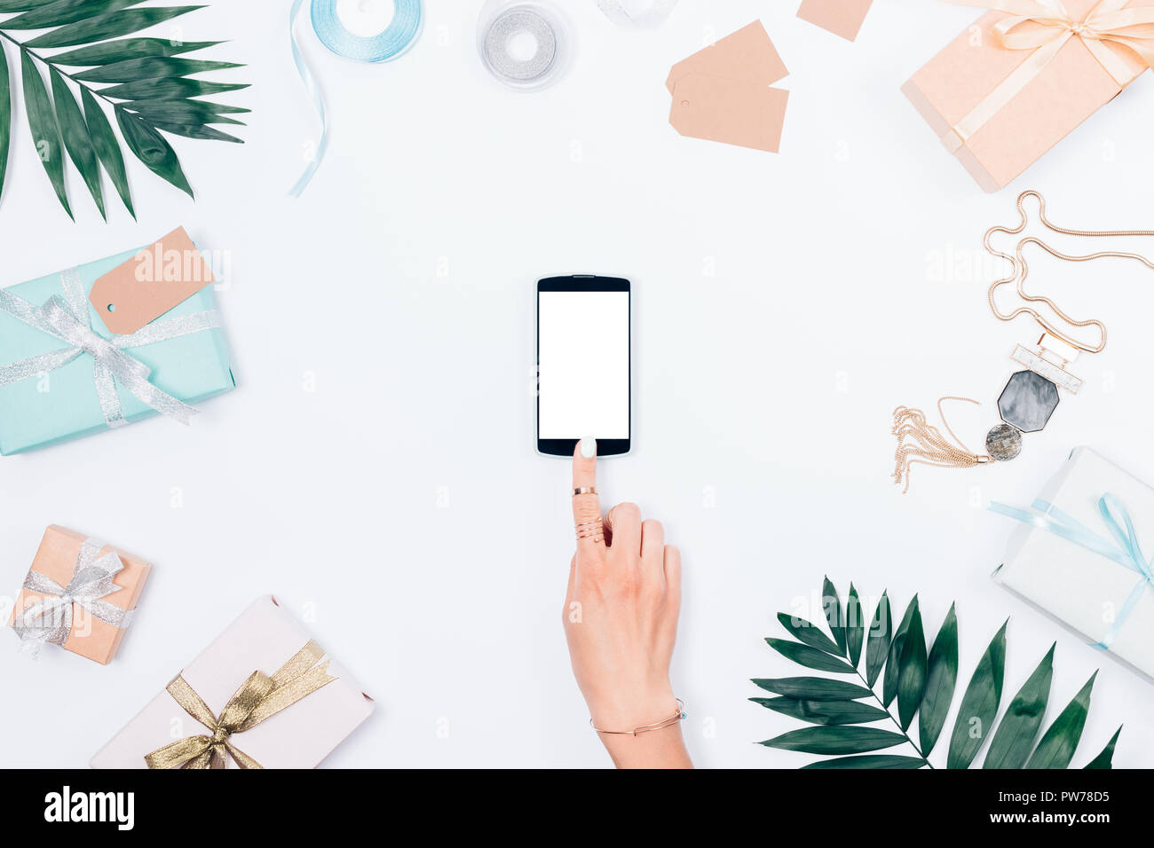 Female hand touching screen of mobile phone among arrangement with palm ...