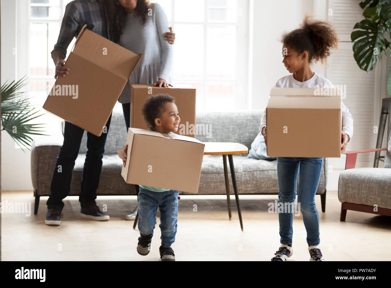 Happy family with kids moving at new home Stock Photo - Alamy