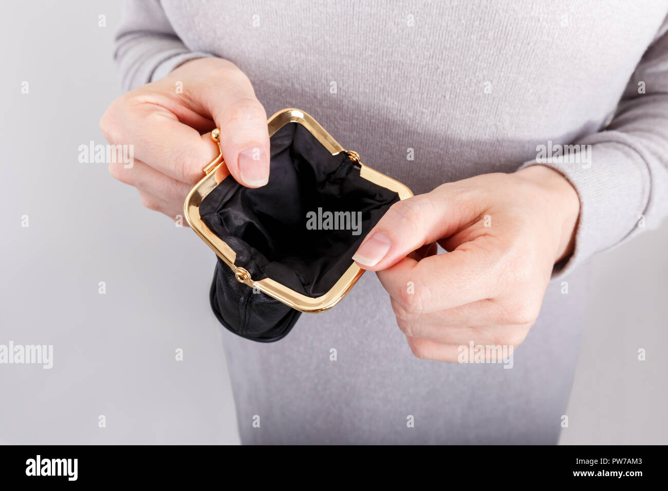 Woman holding open black empty wallet wearing gray clothes Stock Photo ...