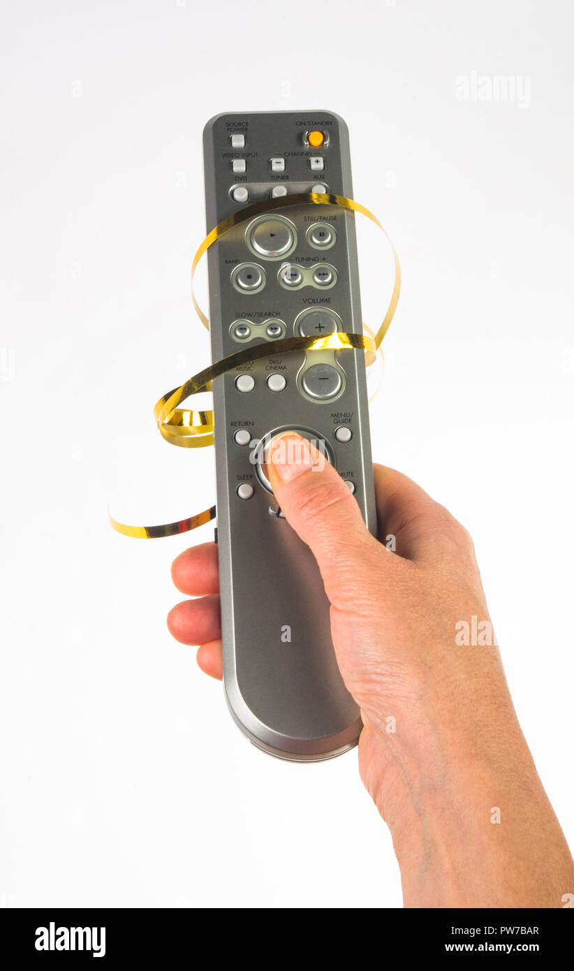 hand holding a remote control in a festive gold ribbon on white ...