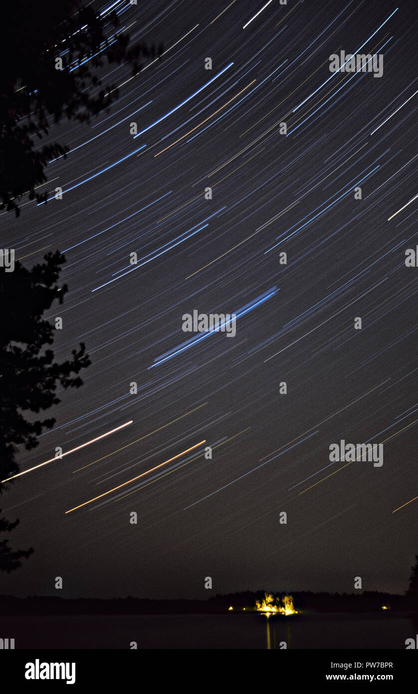 Long exposure star trails rotating around the North Star. Cottage ...