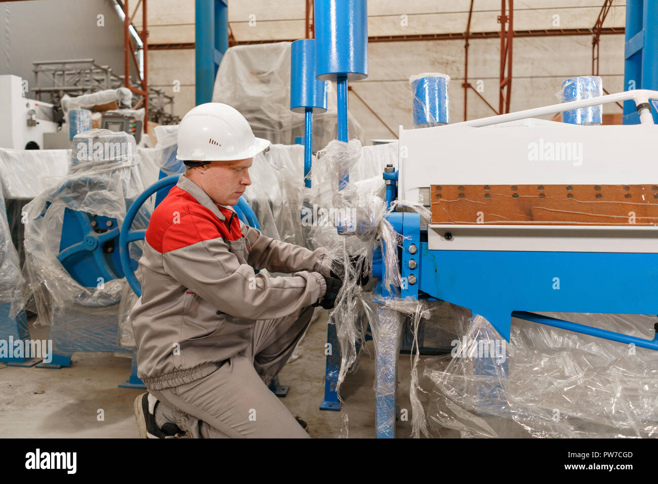 manufacture workshop. Worker unpacks the machine in the warehouse. the ...