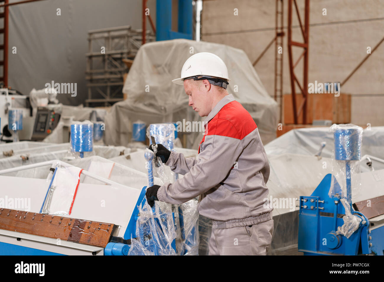 manufacture workshop. Worker unpacks the machine in the warehouse. the ...
