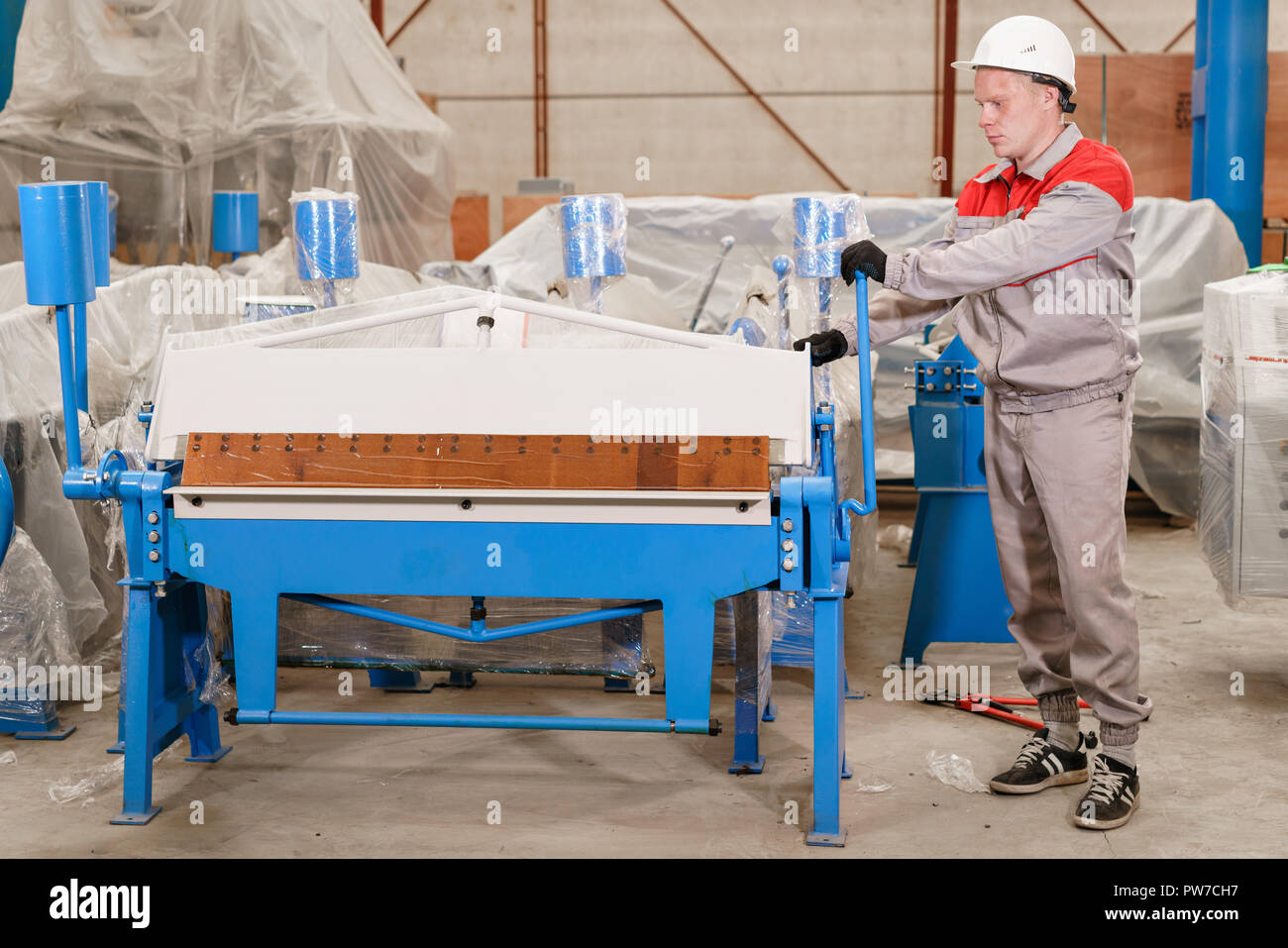 manufacture workshop. Worker unpacks the machine in the warehouse. the ...