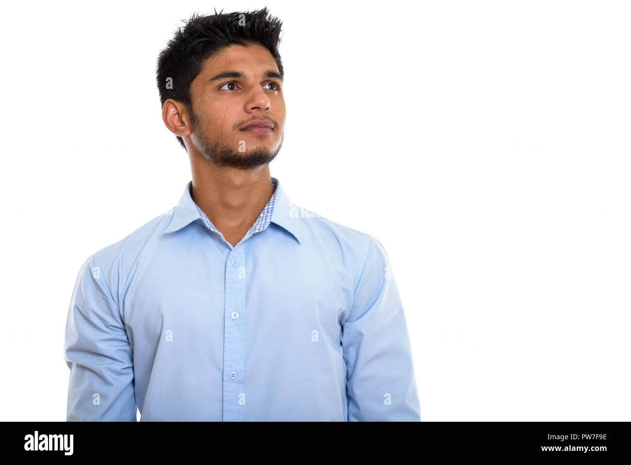 Studio shot of young handsome Indian man thinking while looking Stock ...