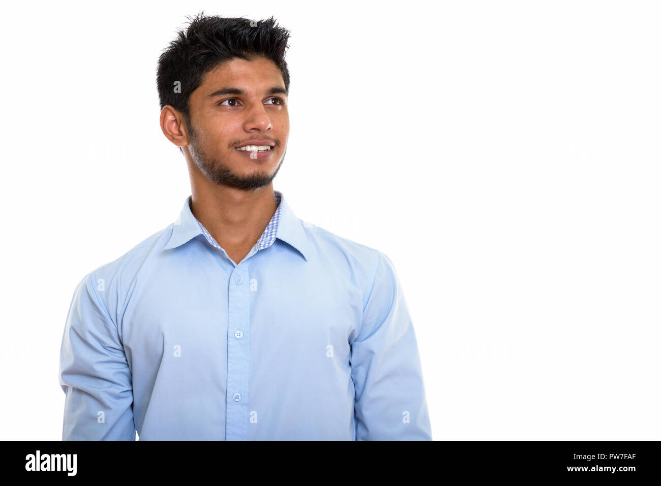 Studio shot of young happy Indian man smiling and thinking while Stock ...