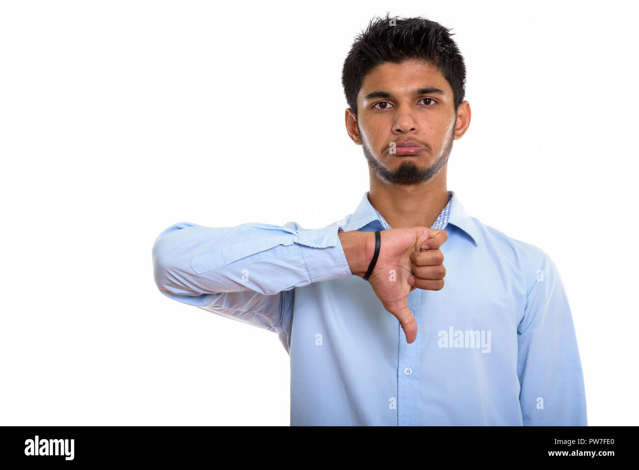 Studio shot of young sad Indian man giving thumb down Stock Photo - Alamy