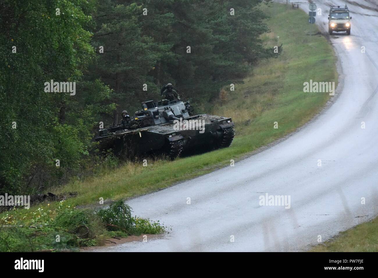 A Swedish CV90 Infantry Fighting Vehicle maneuvers through the tree ...