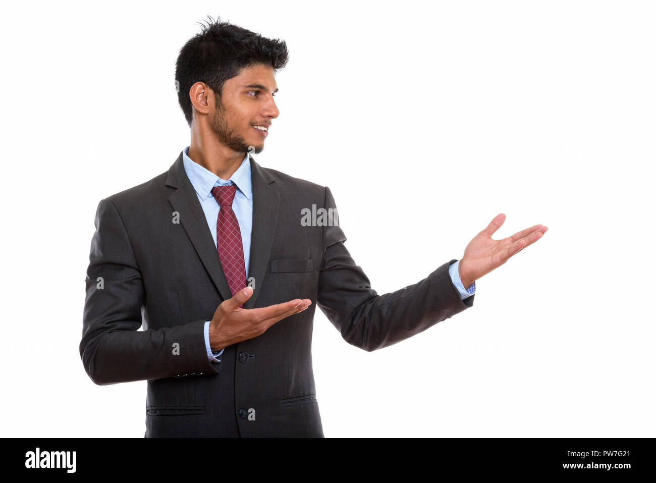 Profile view of young happy Indian businessman smiling while sho Stock ...