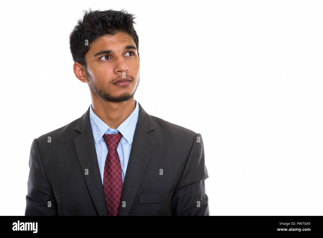 Studio shot of young handsome Indian businessman thinking while Stock ...