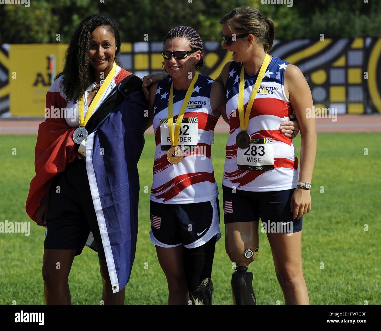 The three women's 100 meter dash finalists pose for a photo after a ...