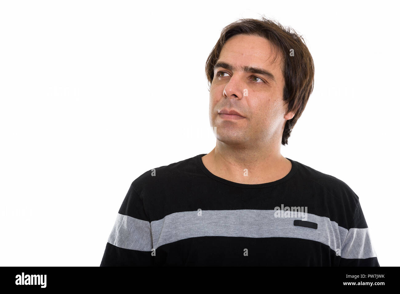 Studio shot of young Persian man thinking while looking up Stock Photo ...