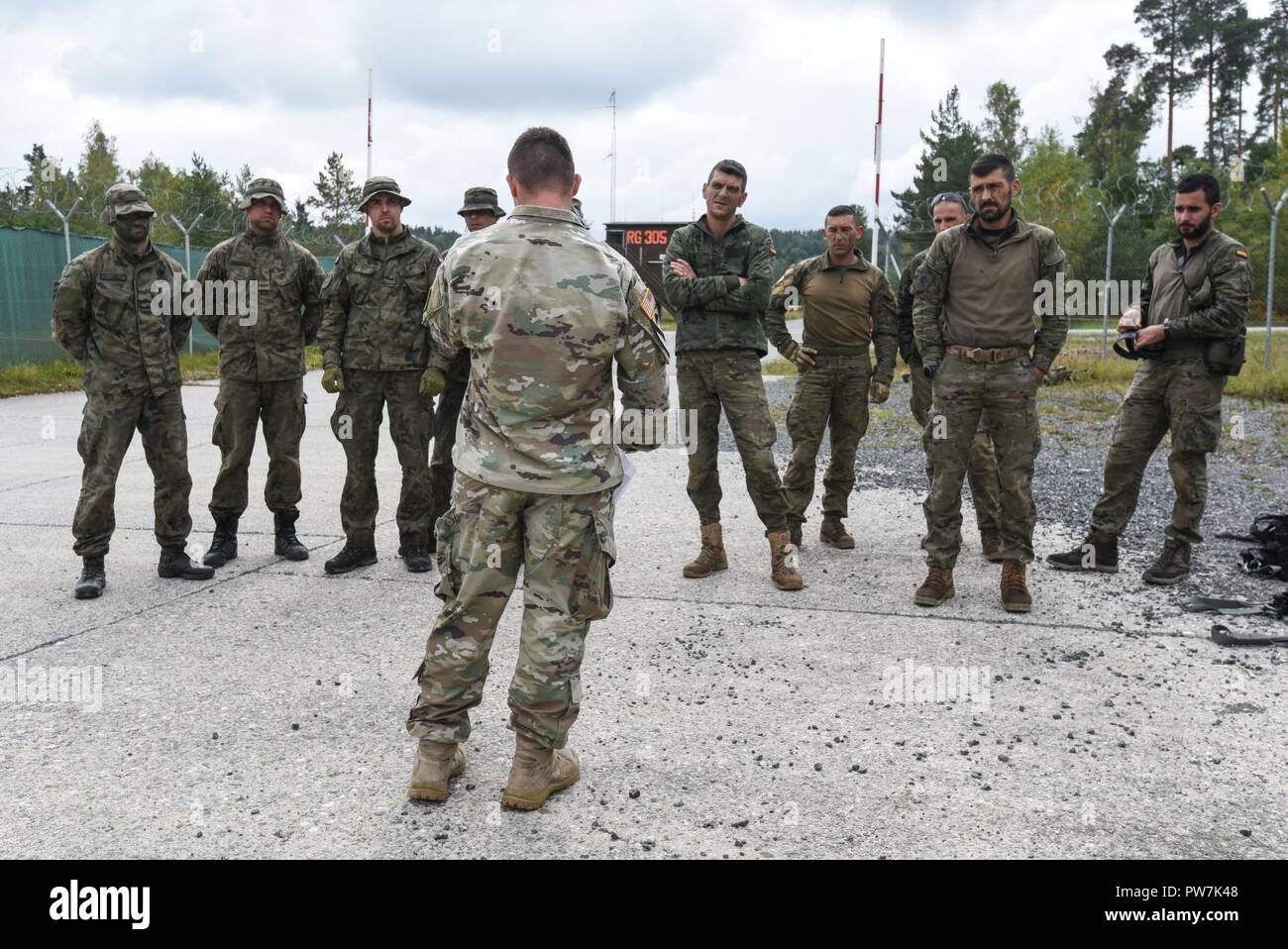 Polish and Spanish soldiers listen to a briefing prior to the high ...