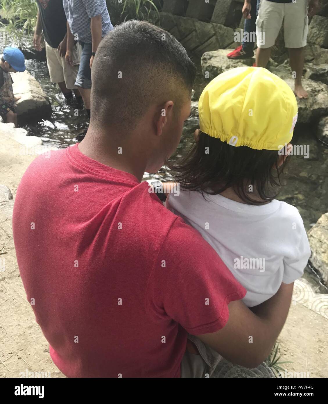 Lance Cpl. Andrew L. Bush sits with a child from Asunaro Higashi, a ...