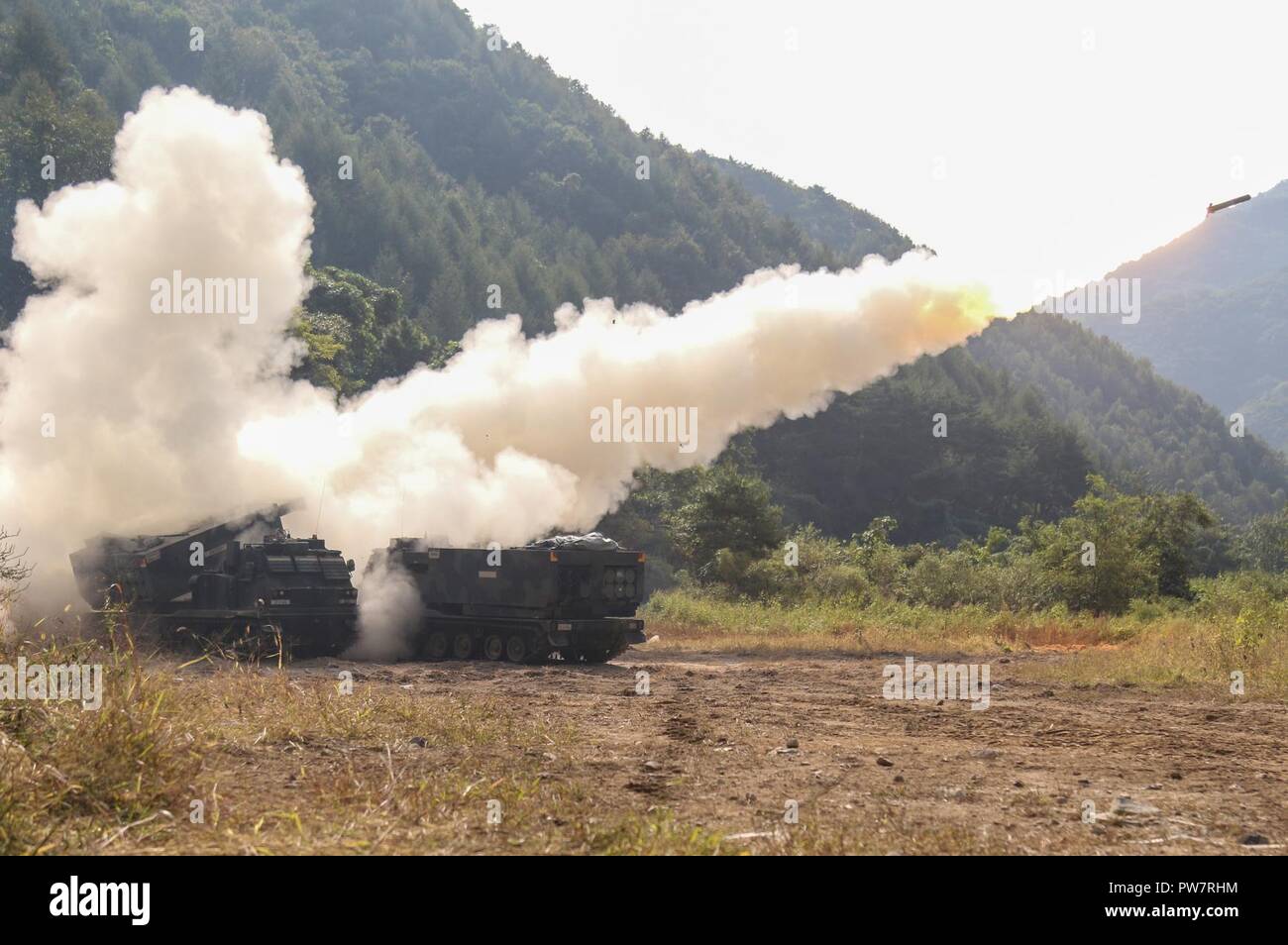 An M270 multiple launch rocket system fires during a live fire training ...