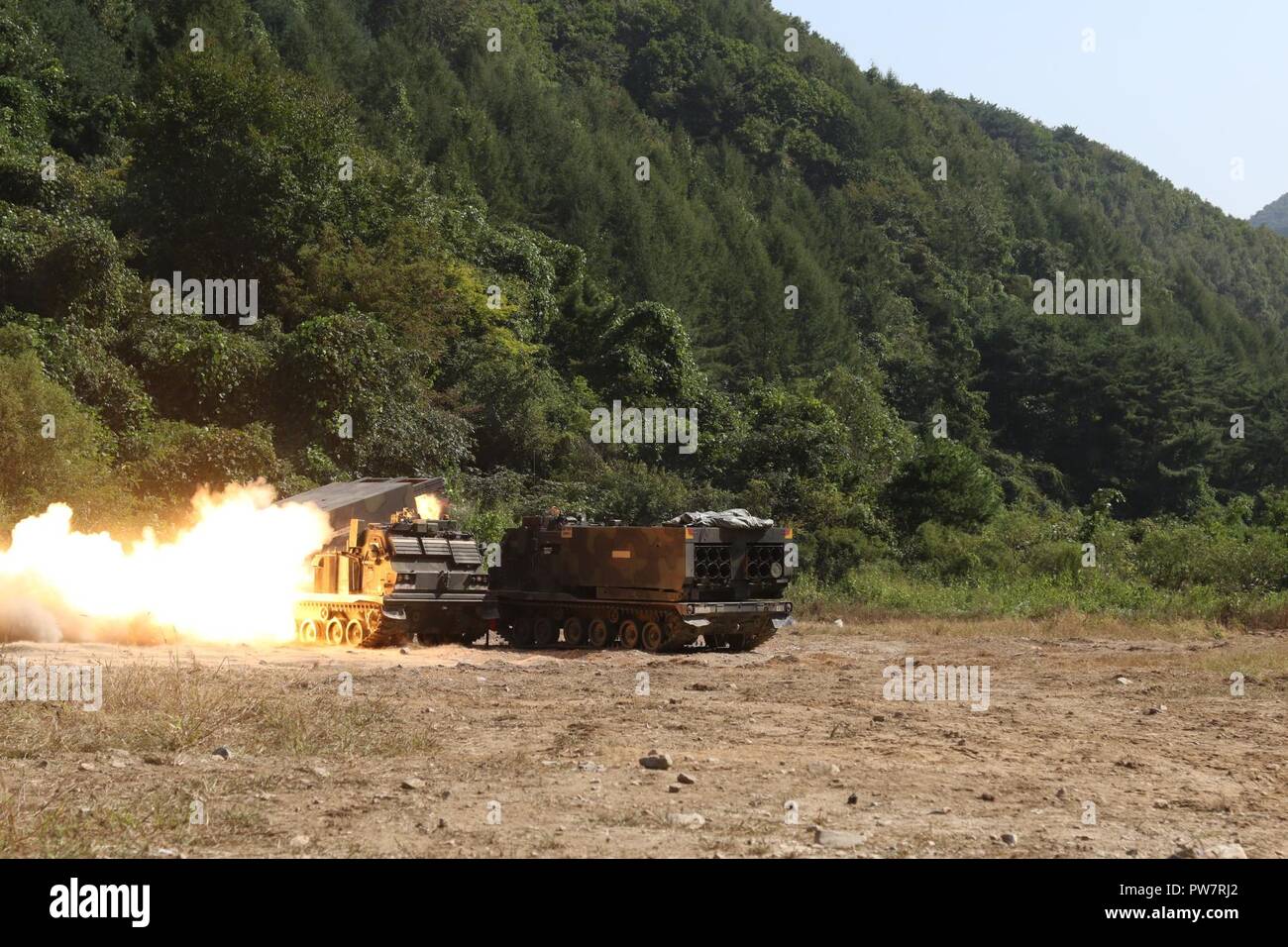 An M270 multiple launch rocket system fires during a live fire training ...