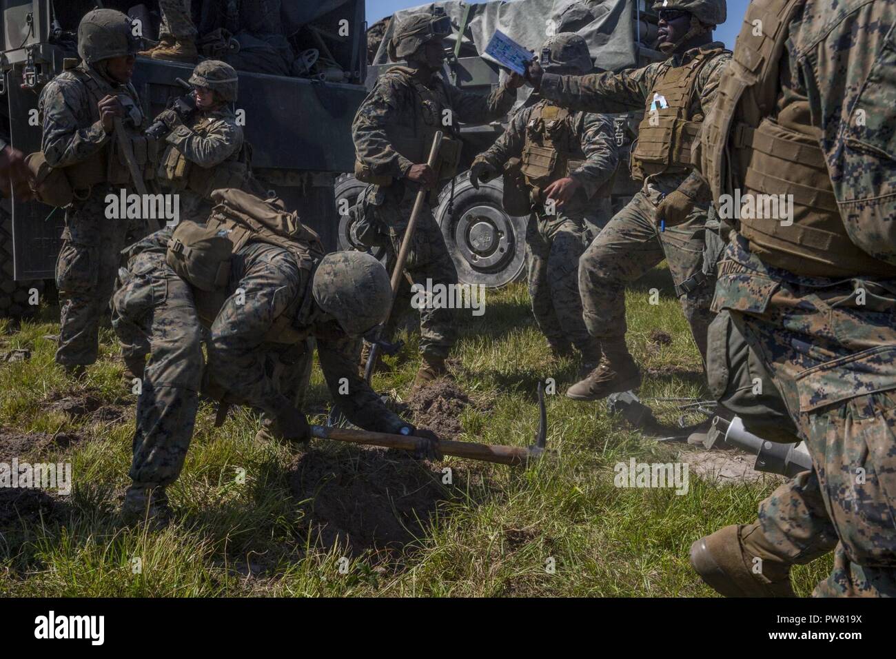 Marines dig holes to emplace an M777 howitzer during a Marine Corps ...