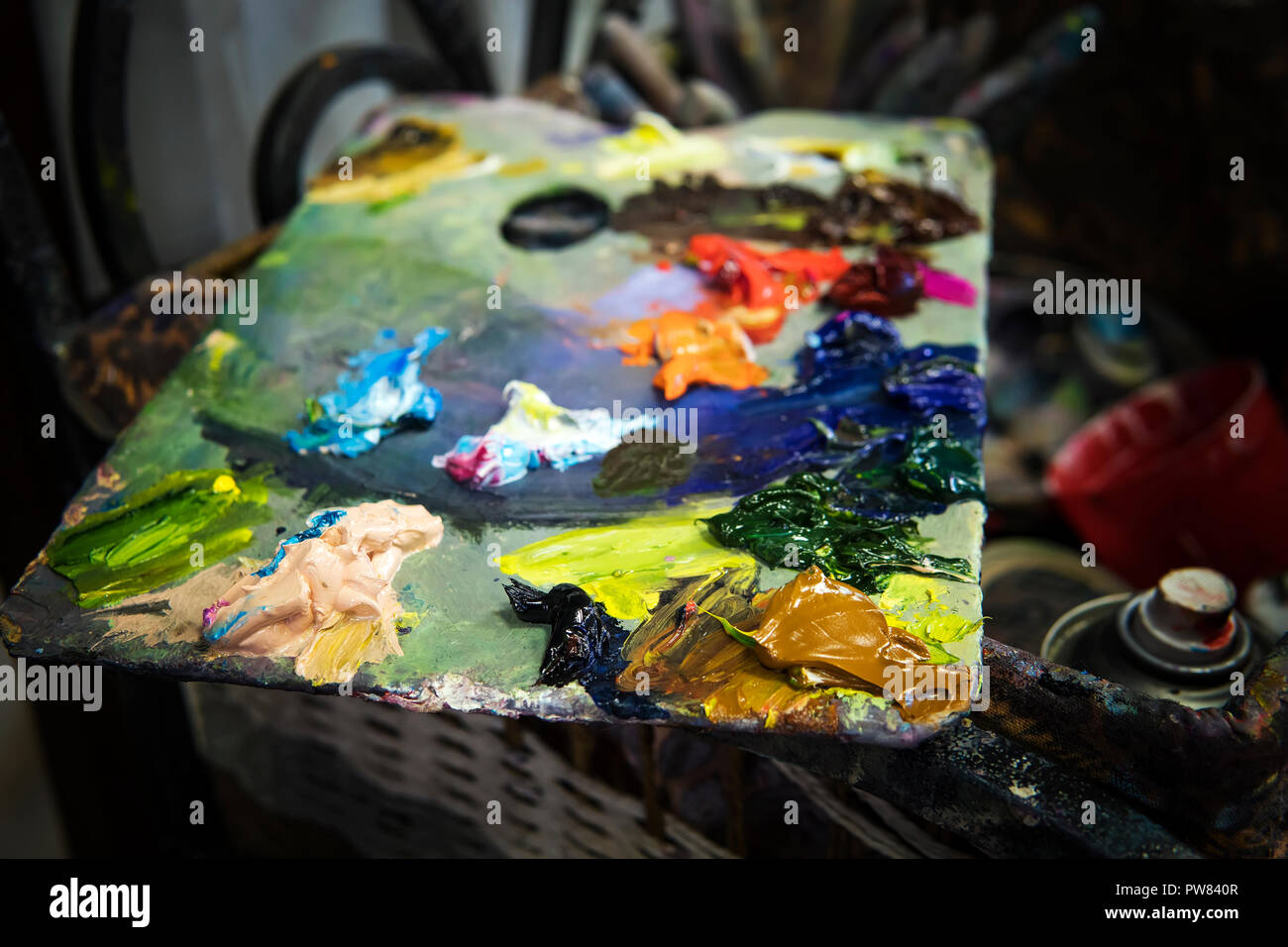 A close up of a varicoloured oil pallette in a painter workroom. An ...