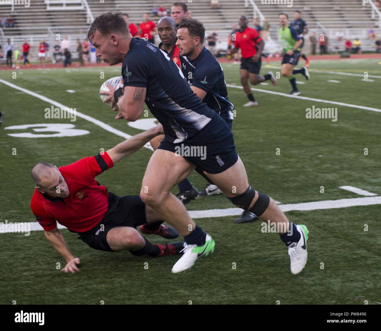 A Royal Sailor assigned the Royal Navy Rugby Team runs with the ball ...