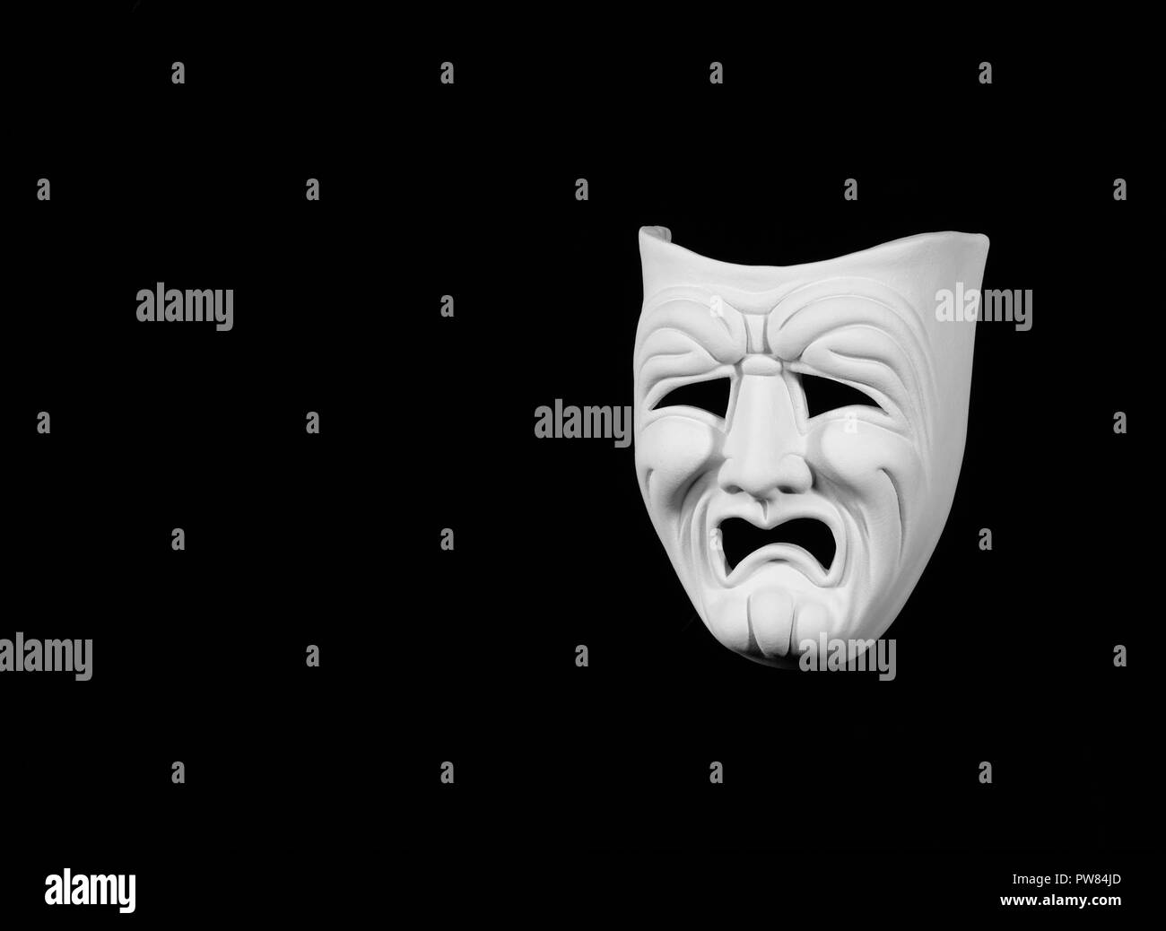 theatre mask expresing the tragedy, white mask on black background with ...
