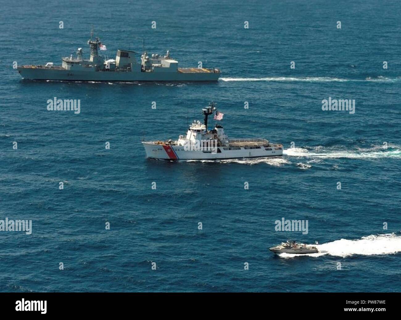 The crew of the Coast Guard Cutter Active (center) participates in a ...