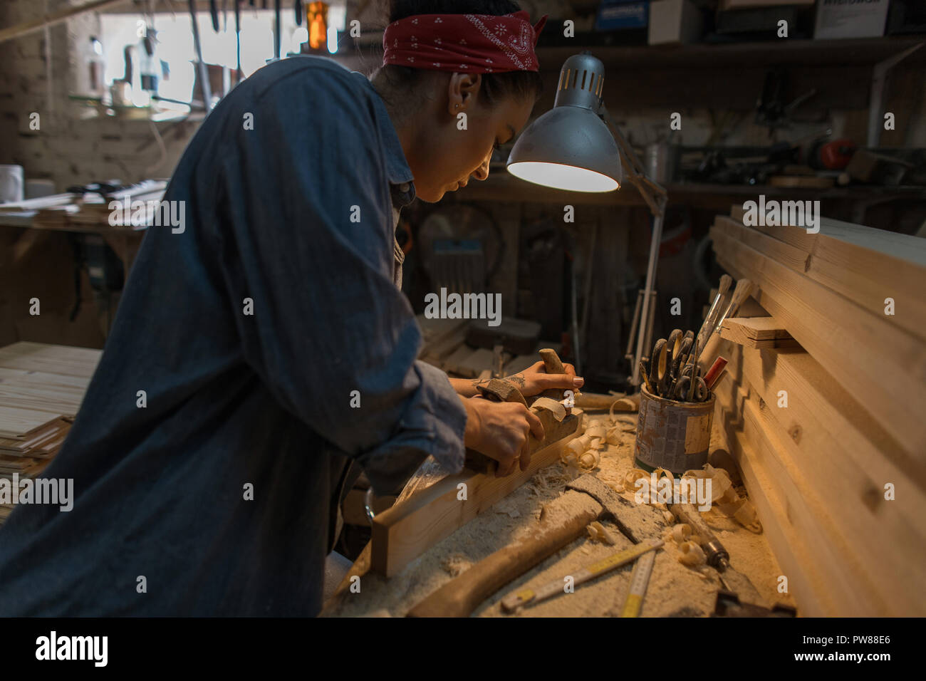 Beautiful woman carpenter working in a wood workshop. Handmade concept ...