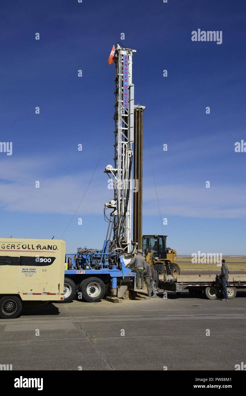 Contract environmental well drillers drill a water well on the ramp of ...