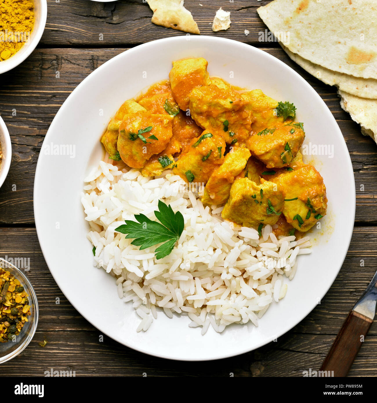 Chicken curry with rice on plate over wooden background. Top view, flat ...
