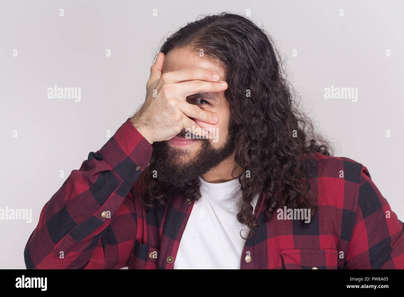 Portrait of handsome funny man with beard and black long curly hair in ...