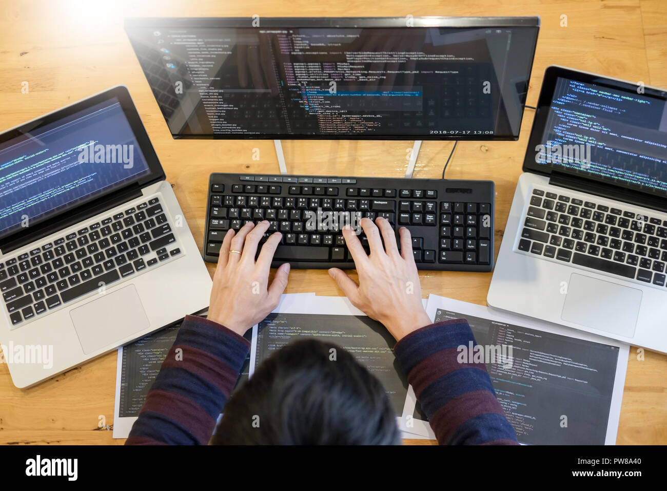 Pensive programmer working on on desktop pc programming code ...