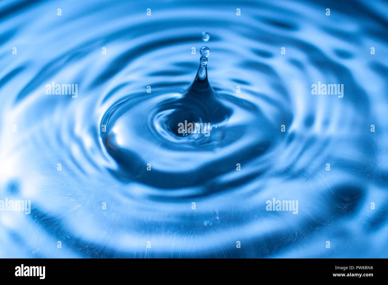 water drop splash in a glass blue colored Stock Photo - Alamy