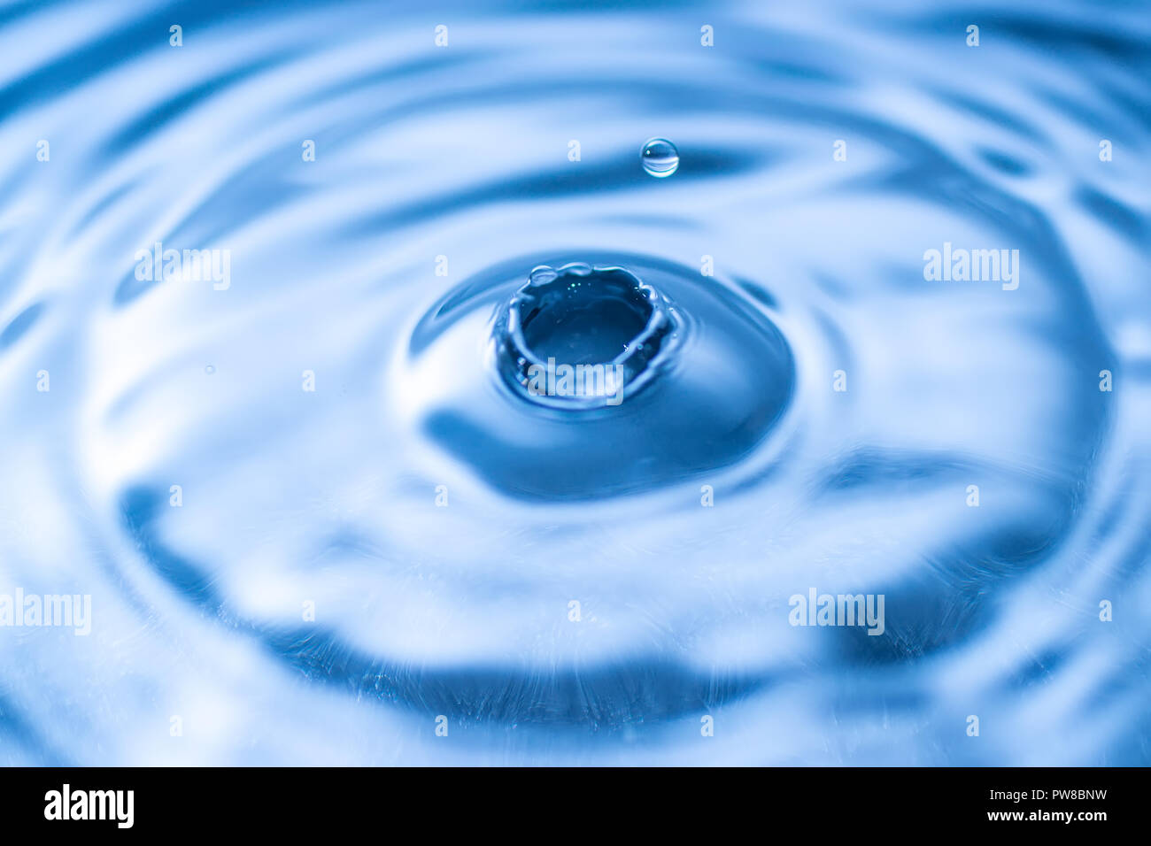 water drop splash in a glass blue colored Stock Photo - Alamy