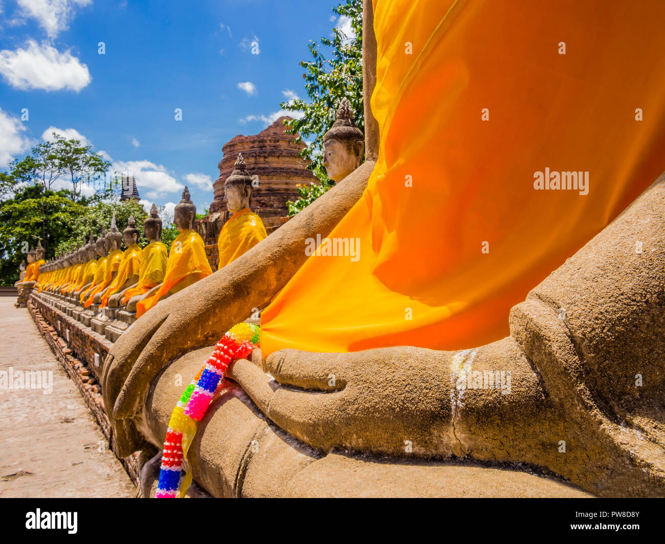 Thailand, impressive row of Buddha statues with orange robes in ...