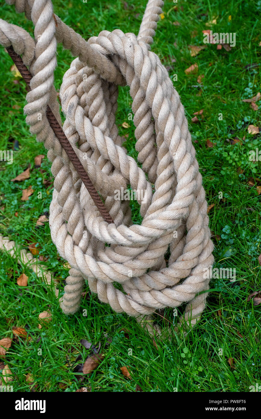 Rope coiled up onto a metal pole in a garden Stock Photo - Alamy