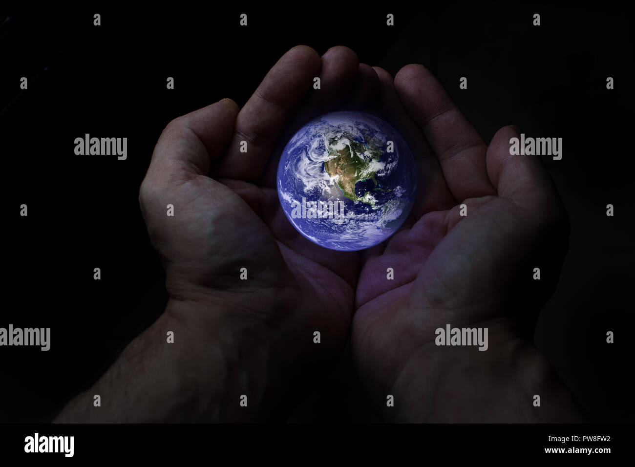 Two hands protect the earth globe. Elements of this image furnished by ...