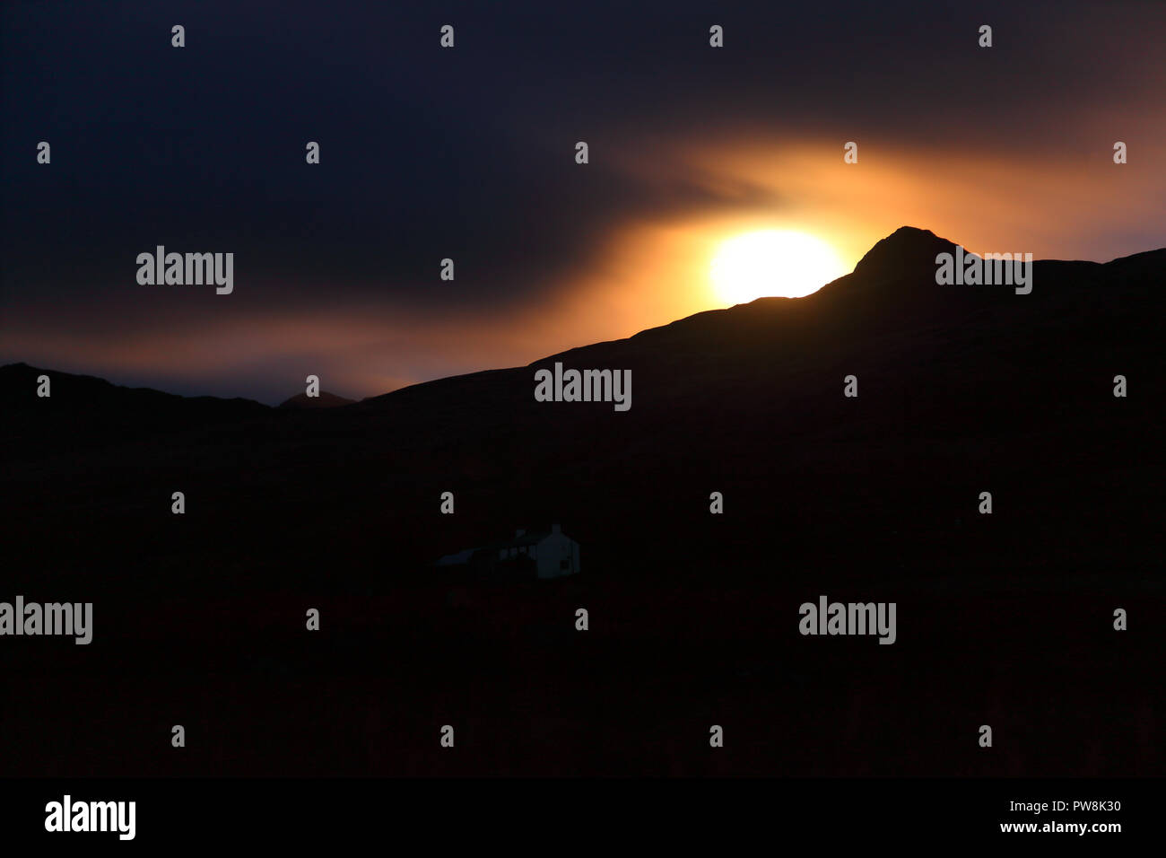 The moon shines bright in the night sky revealing Snowdon Summit in ...