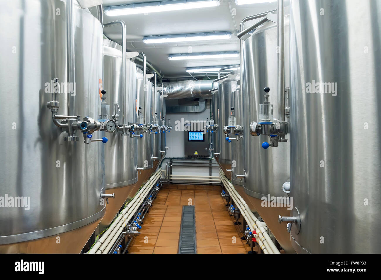 Modern automated beer factory. Lines of metal tanks in modern brewery ...
