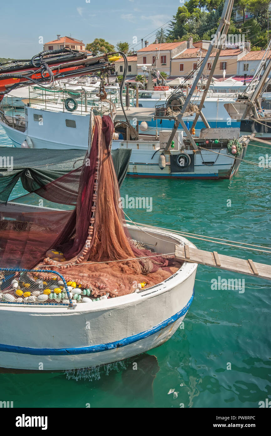 Multi-colored fishing nets are dried on the pier by the sea. Fish ...