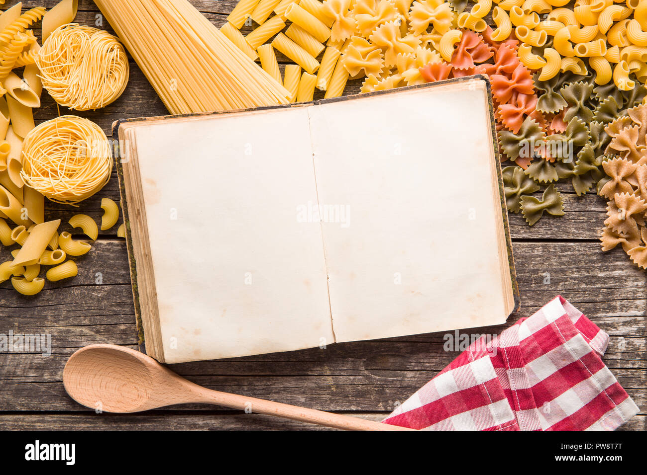 Various types of italian pasta and blank cookbook. Top view Stock Photo ...