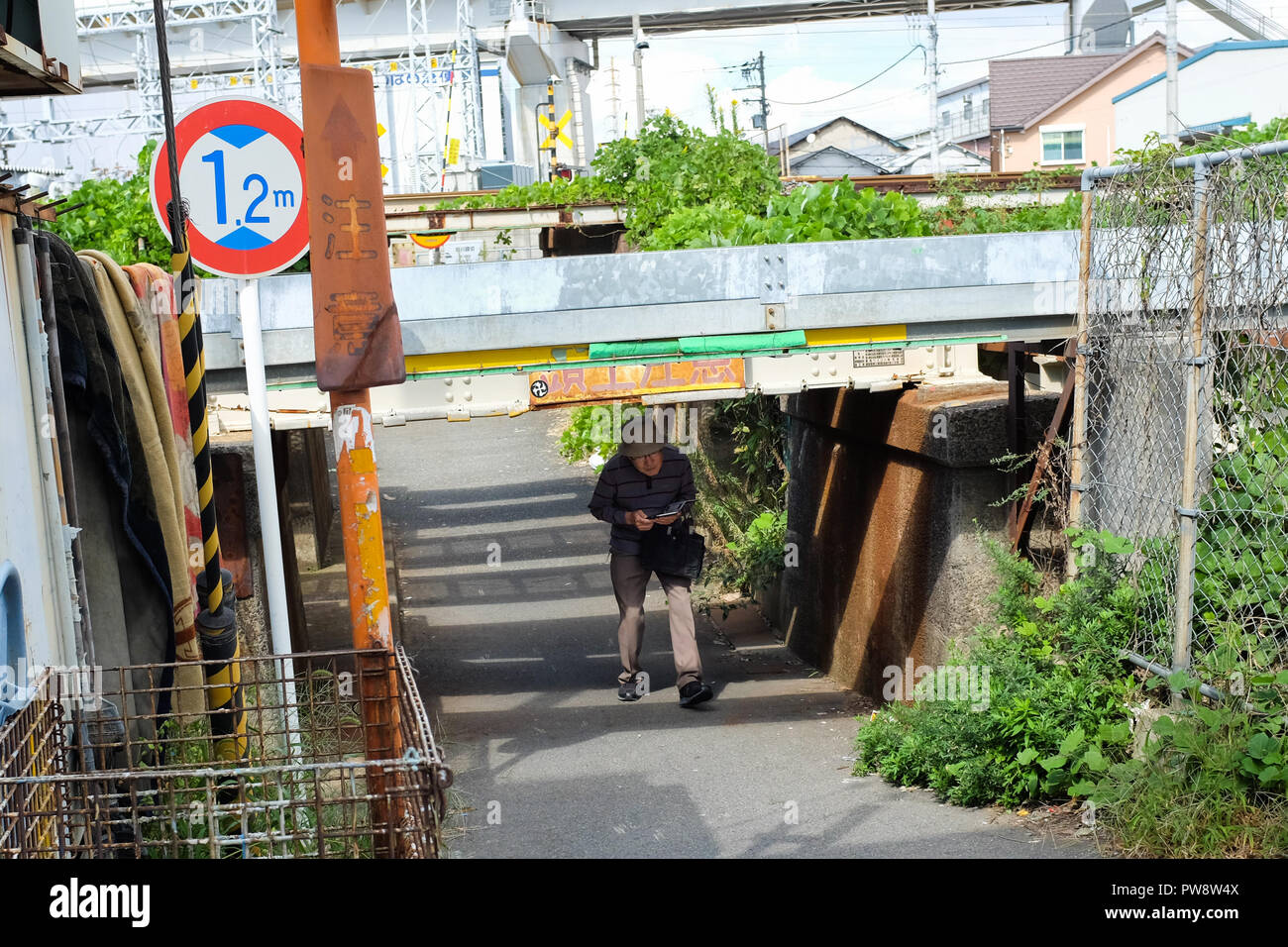 A very low bridge in Osaka, Japan. A railway track passes overhead ...