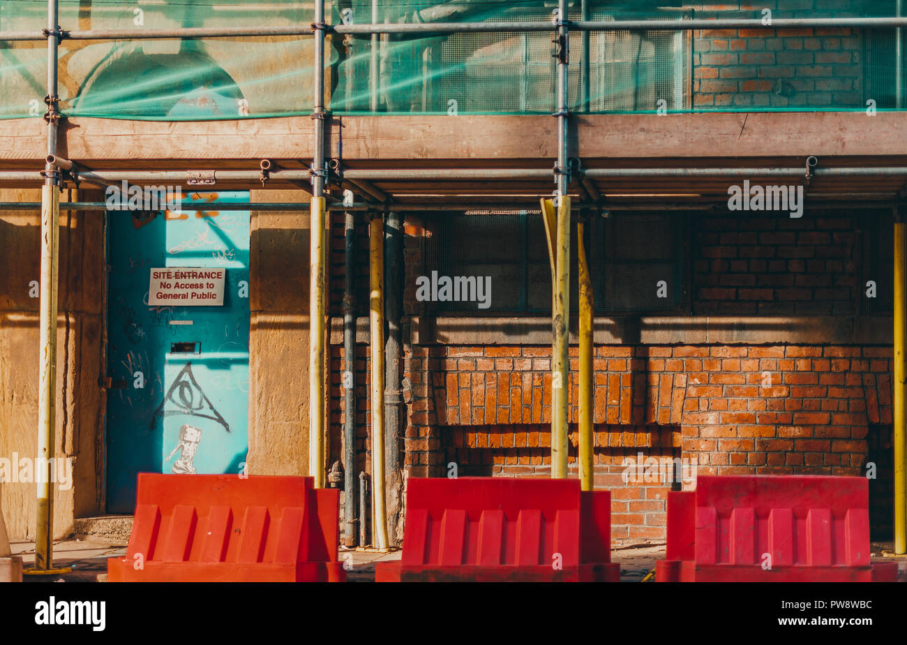 A blue door with a warning sign underneath some scaffolding in ...