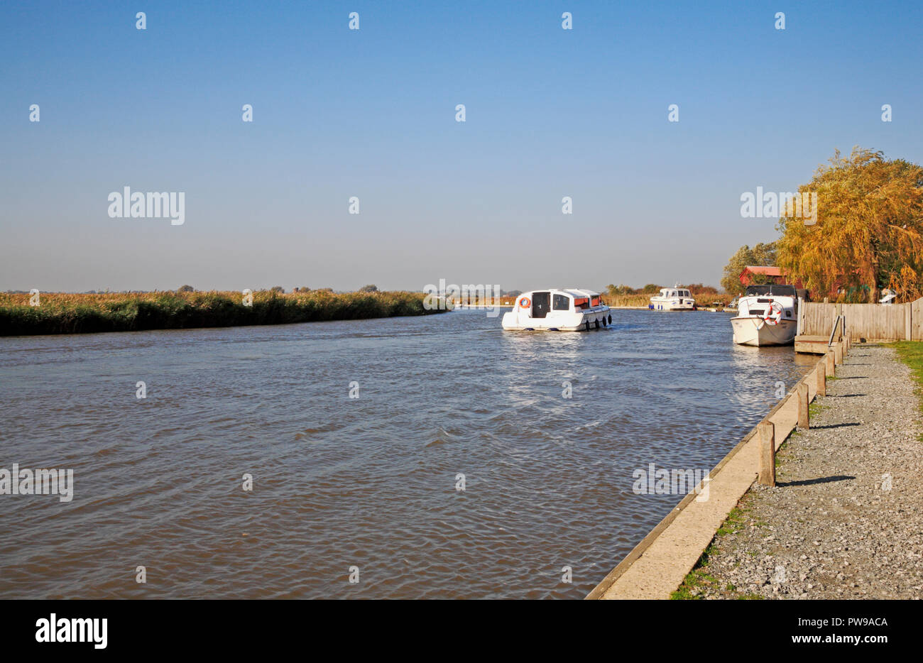 A cruiser on the River Bure on the Norfolk Broads on a fine autumn day ...