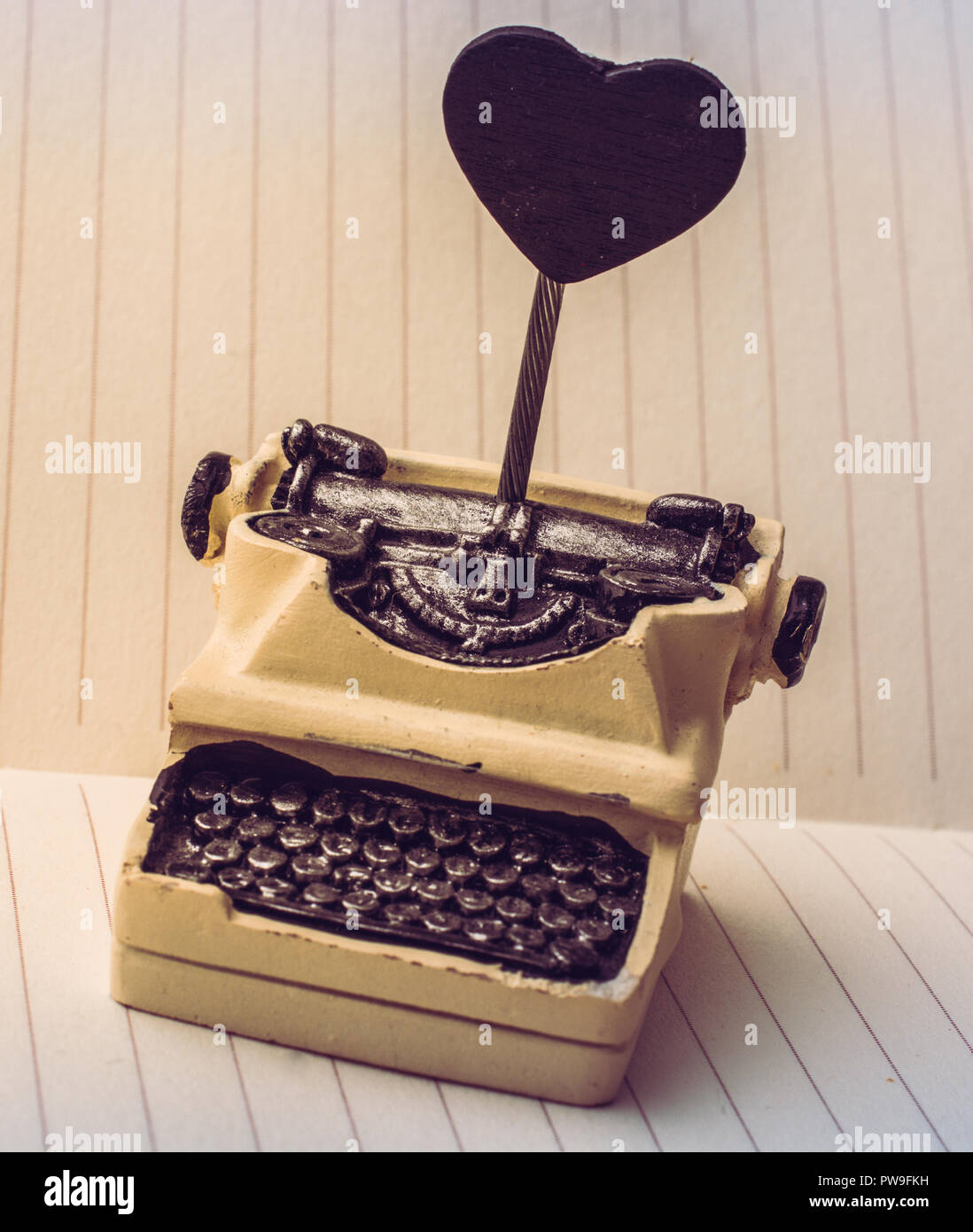 Retro syled tiny typewriter model on a paper background Stock Photo - Alamy