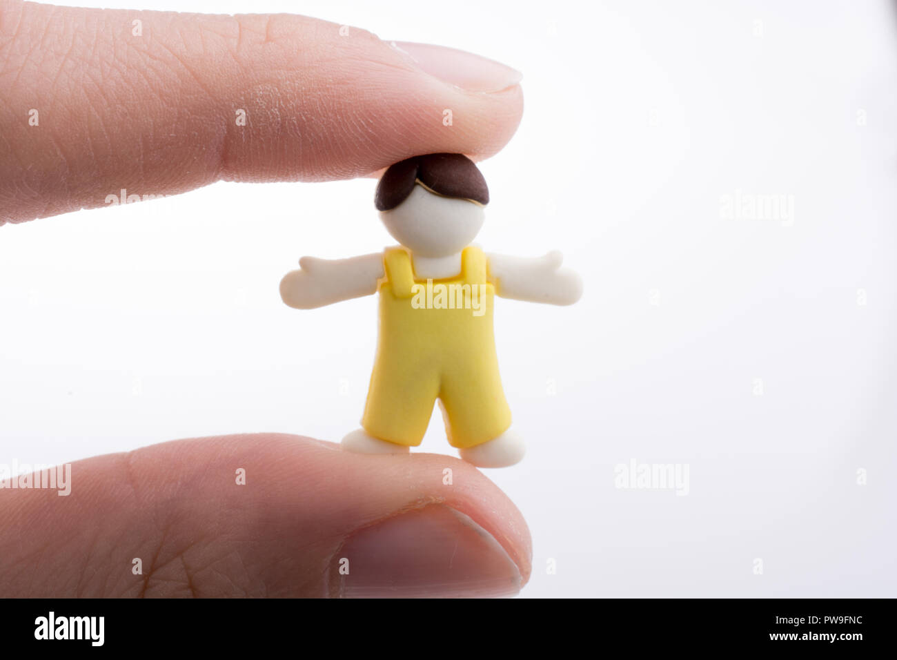 Hand holding a child figure on a white background Stock Photo - Alamy