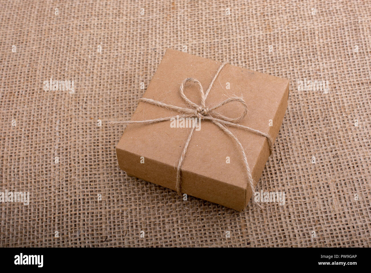 Gift box of brown color on linen canvas Stock Photo - Alamy
