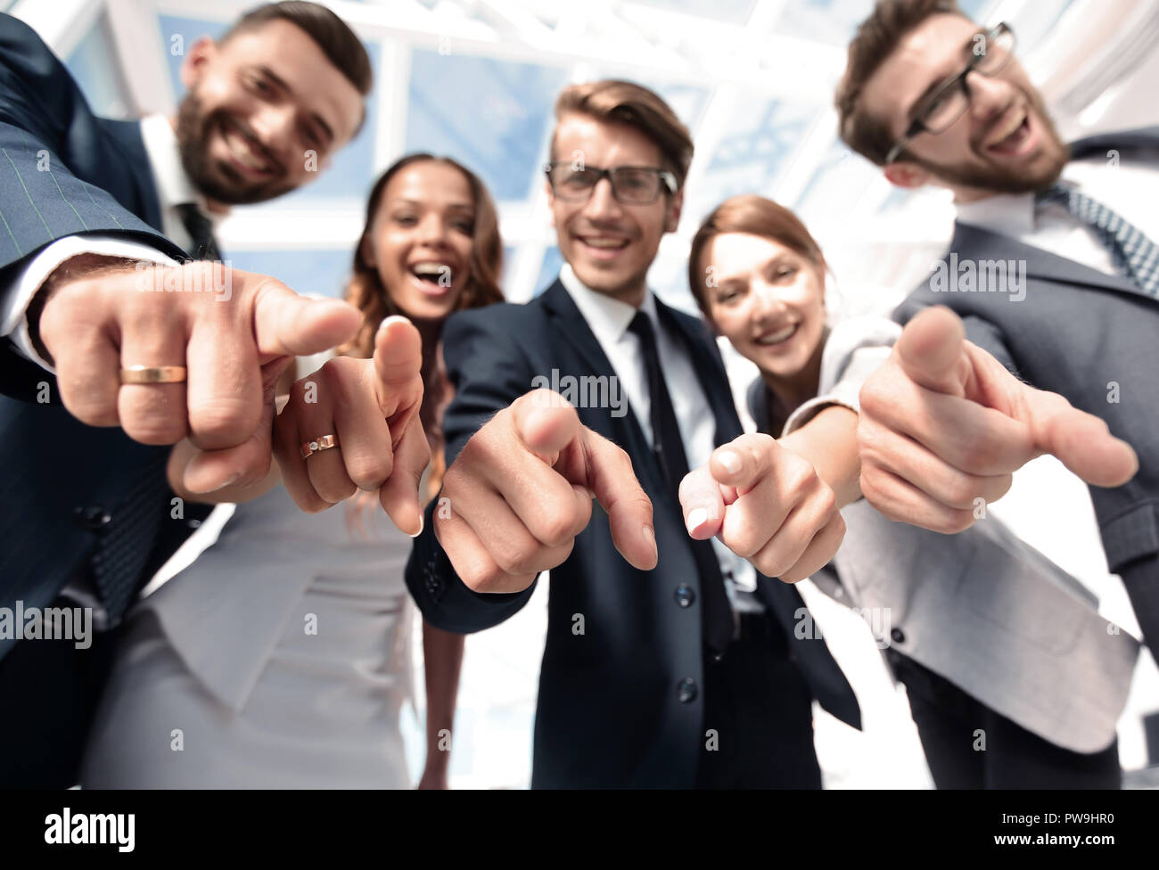 close up.smiling business team pointing at you Stock Photo - Alamy