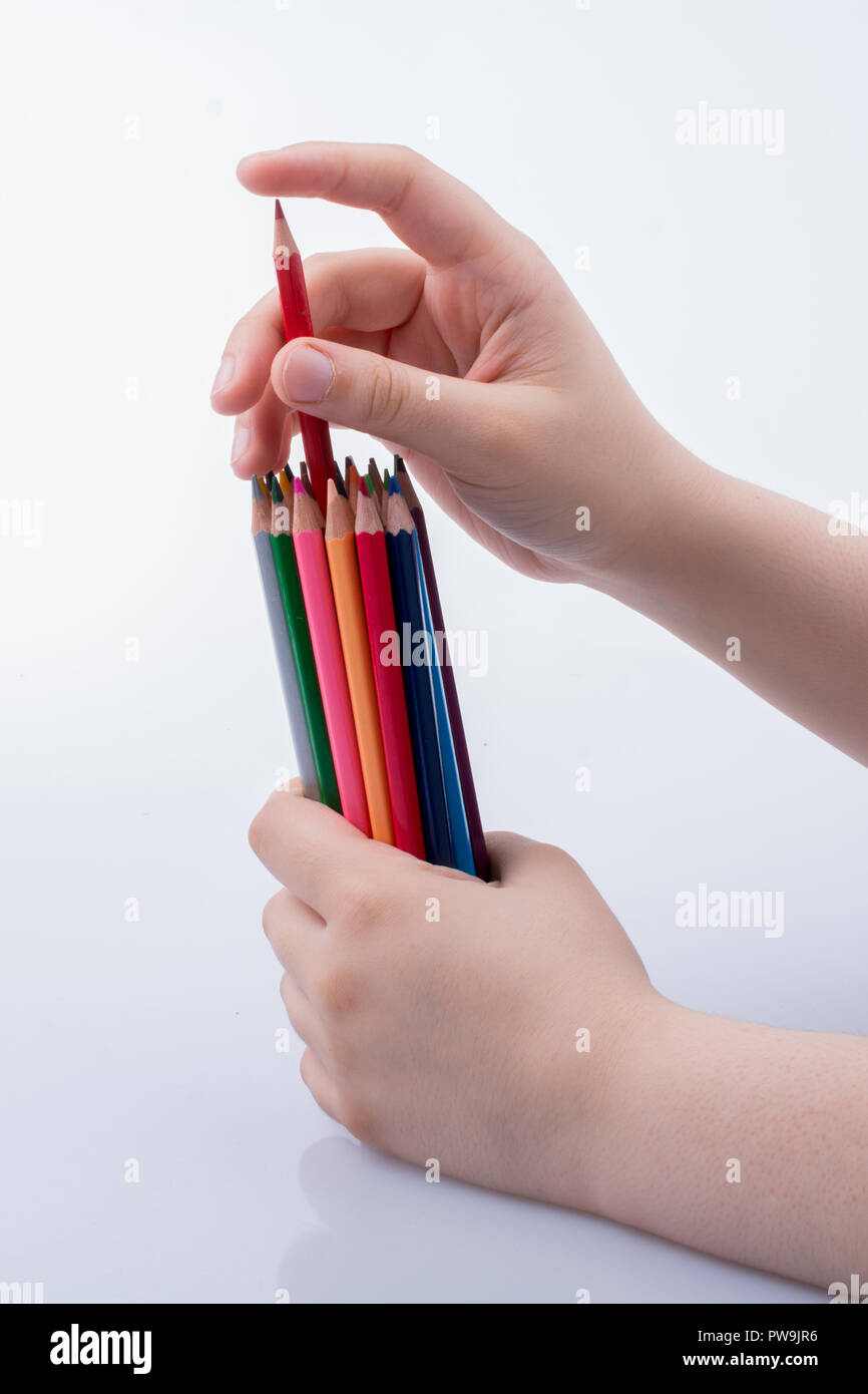 Hand holding color Pencils placed on a white background Stock Photo - Alamy