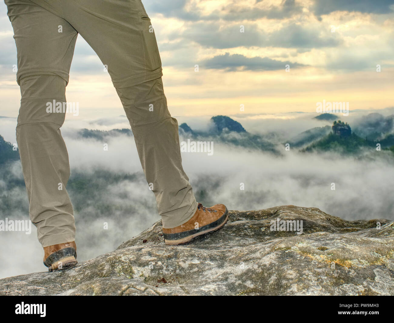 Hiker legs in light outdoor trousers and comfortable leather trekking ...